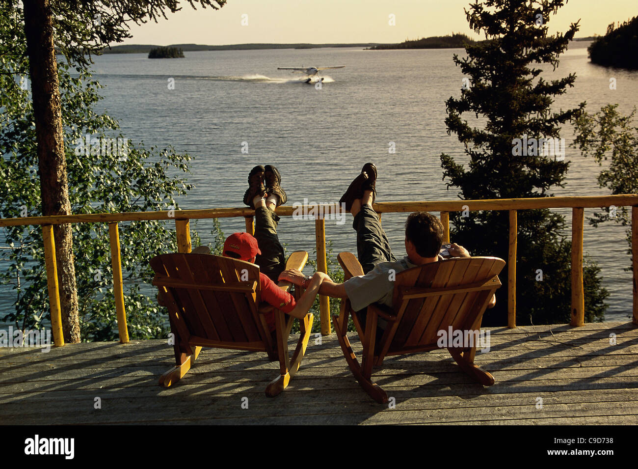 Father and son sitting together on rocking chairs, Canada Stock Photo ...