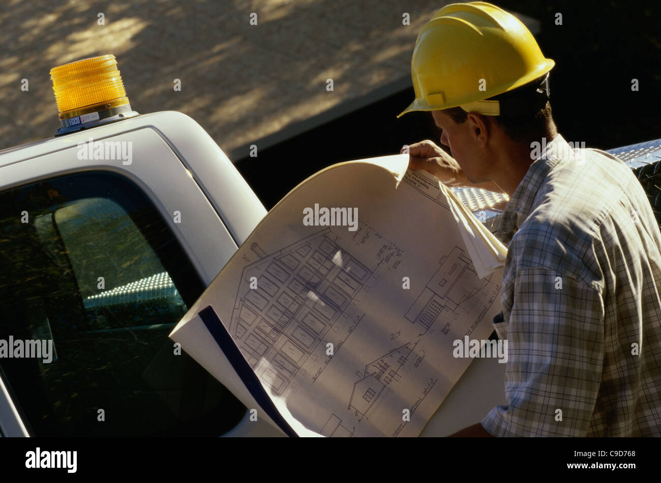 Rear view of a male architect looking at a blueprint Stock Photo - Alamy