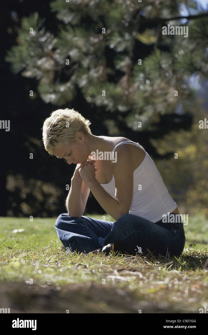 Young woman sitting on a lawn Stock Photo - Alamy