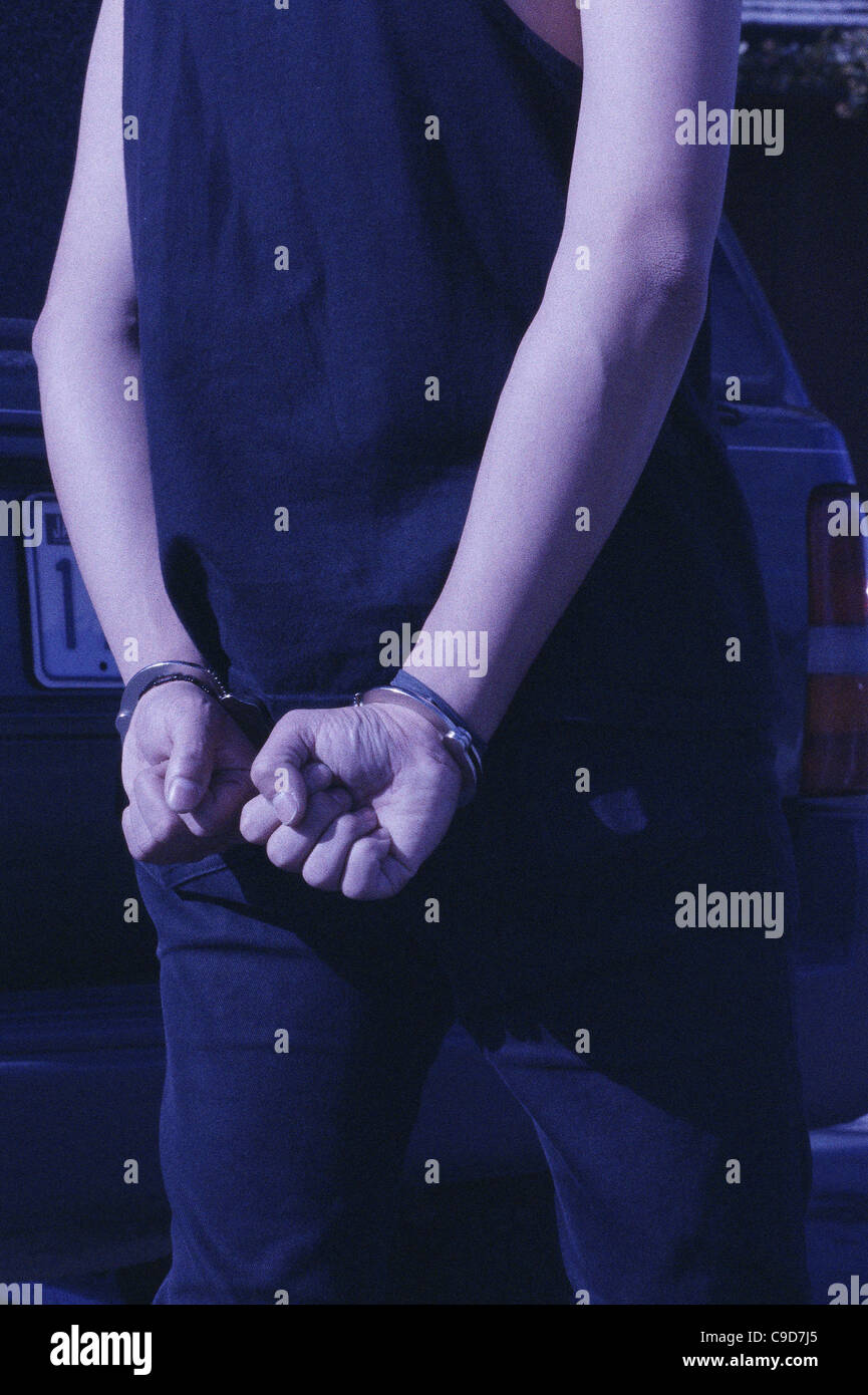 Rear view of a person in handcuffs Stock Photo - Alamy