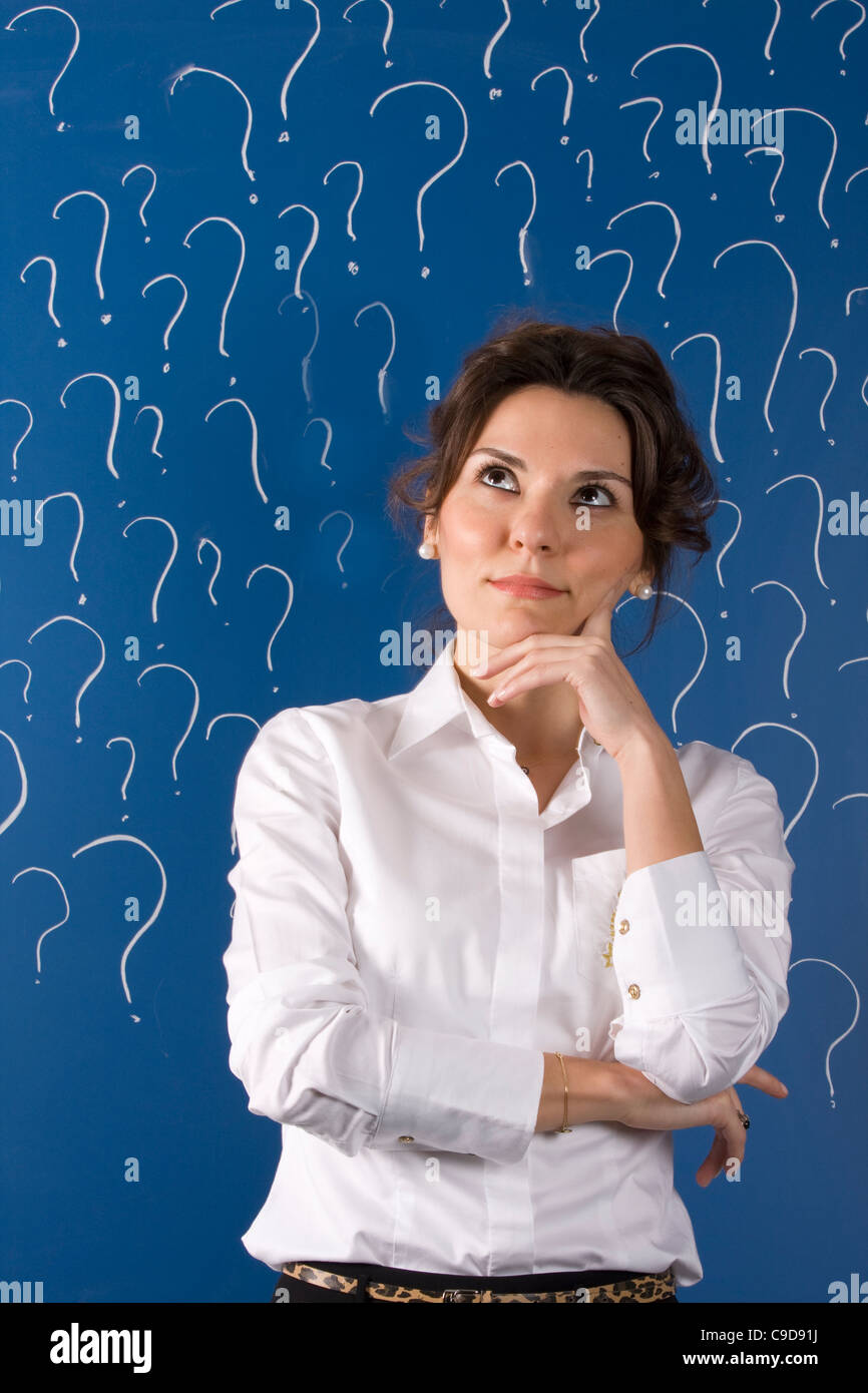 thinking business woman in front of question marks written blackboard ...