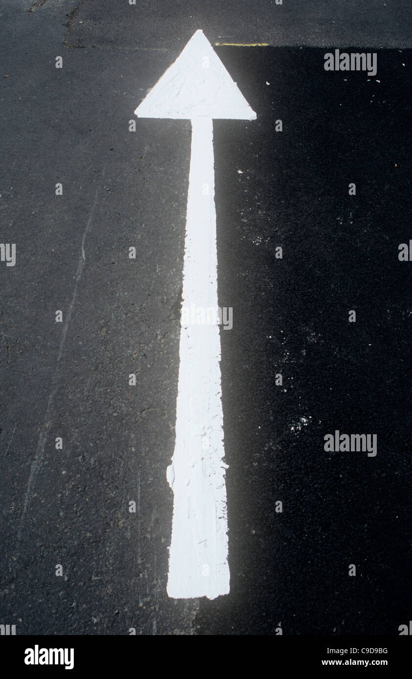 White arrow sign painted on tarmac road surface Stock Photo - Alamy