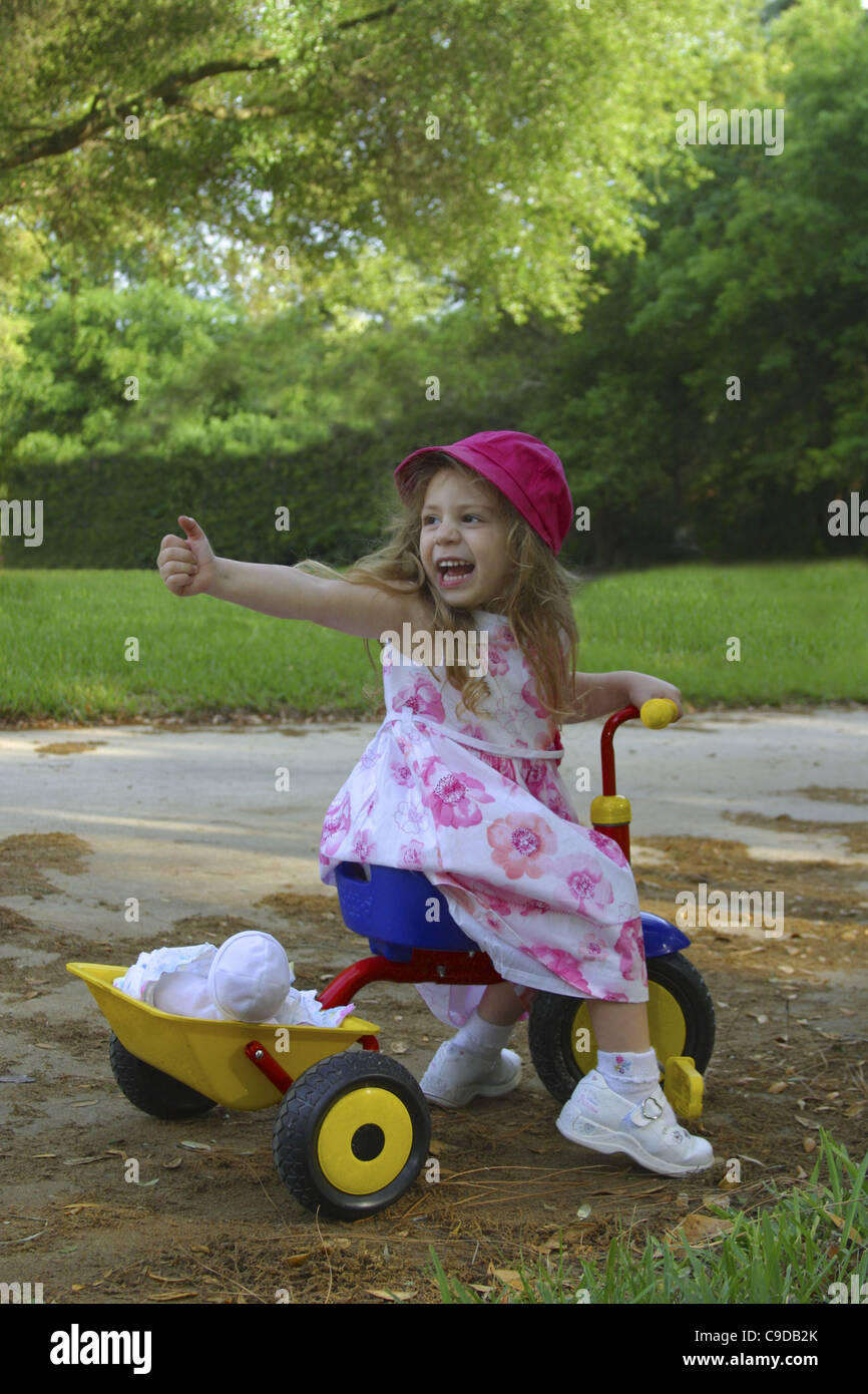 Girl riding a tricycle Stock Photo - Alamy