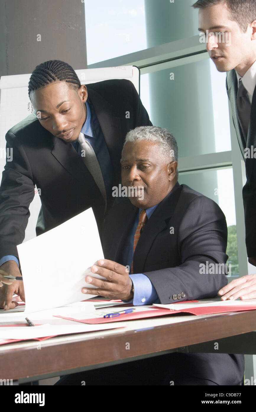 Business men reviewing paperwork Stock Photo - Alamy
