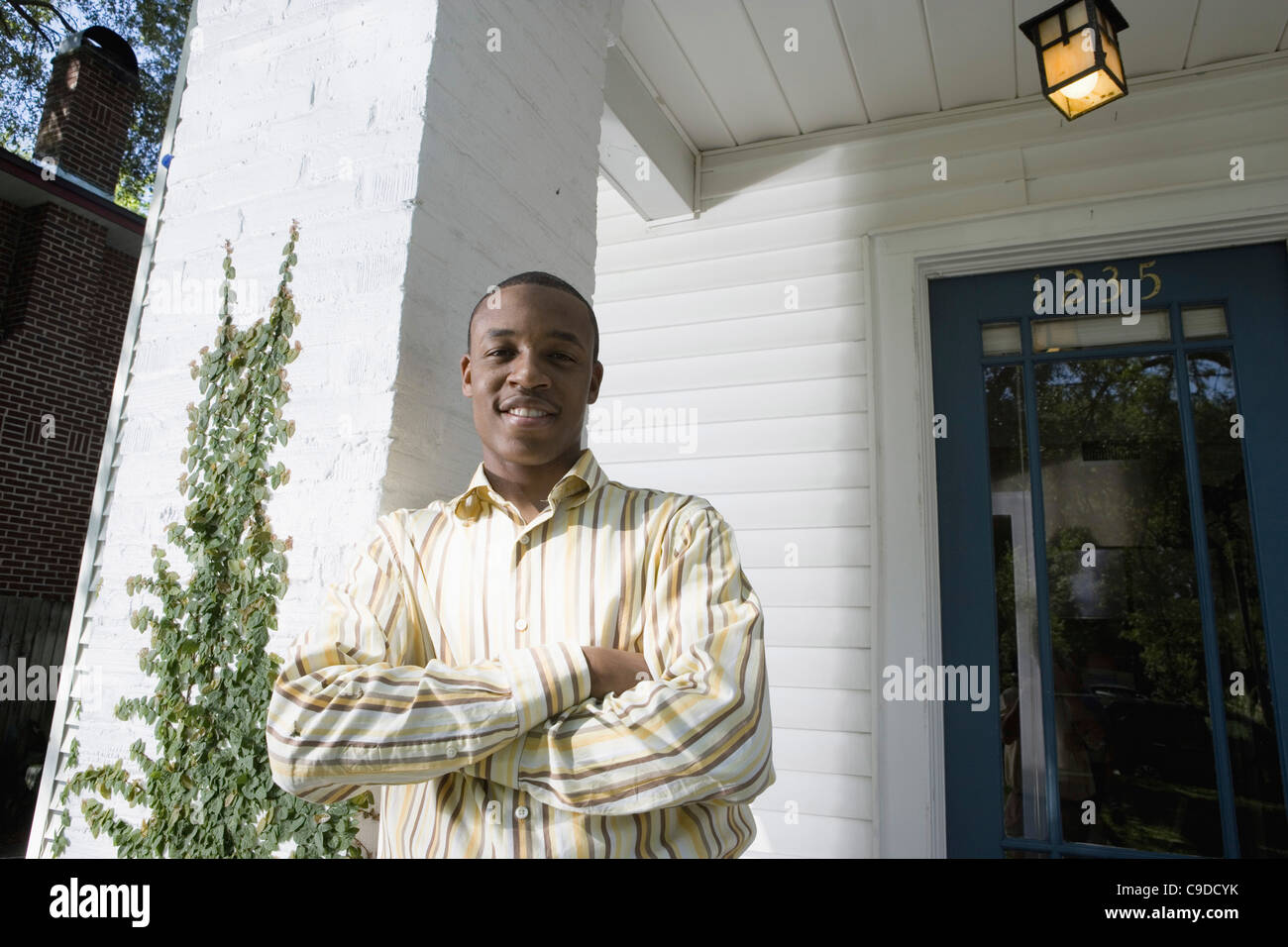 Portrait of a young man standing outside a house Stock Photo - Alamy