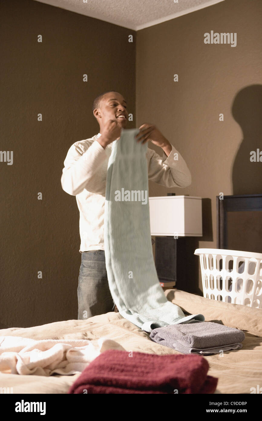 Young man folding towels hi-res stock photography and images - Alamy