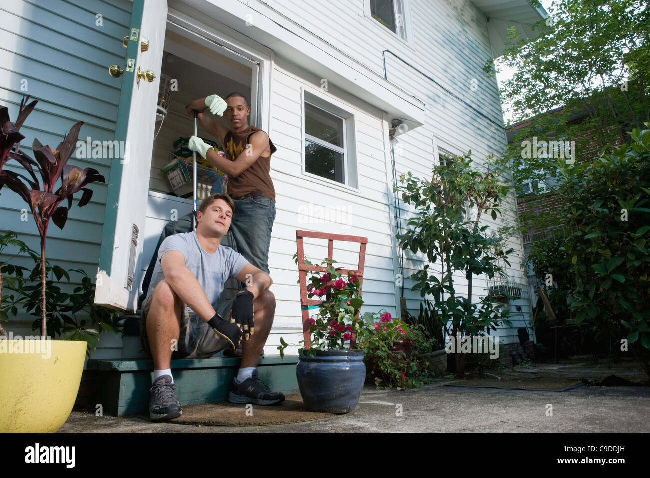 Two young men doing house chores Stock Photo - Alamy