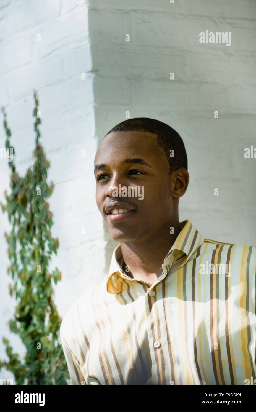 Young man standing outside a house Stock Photo - Alamy