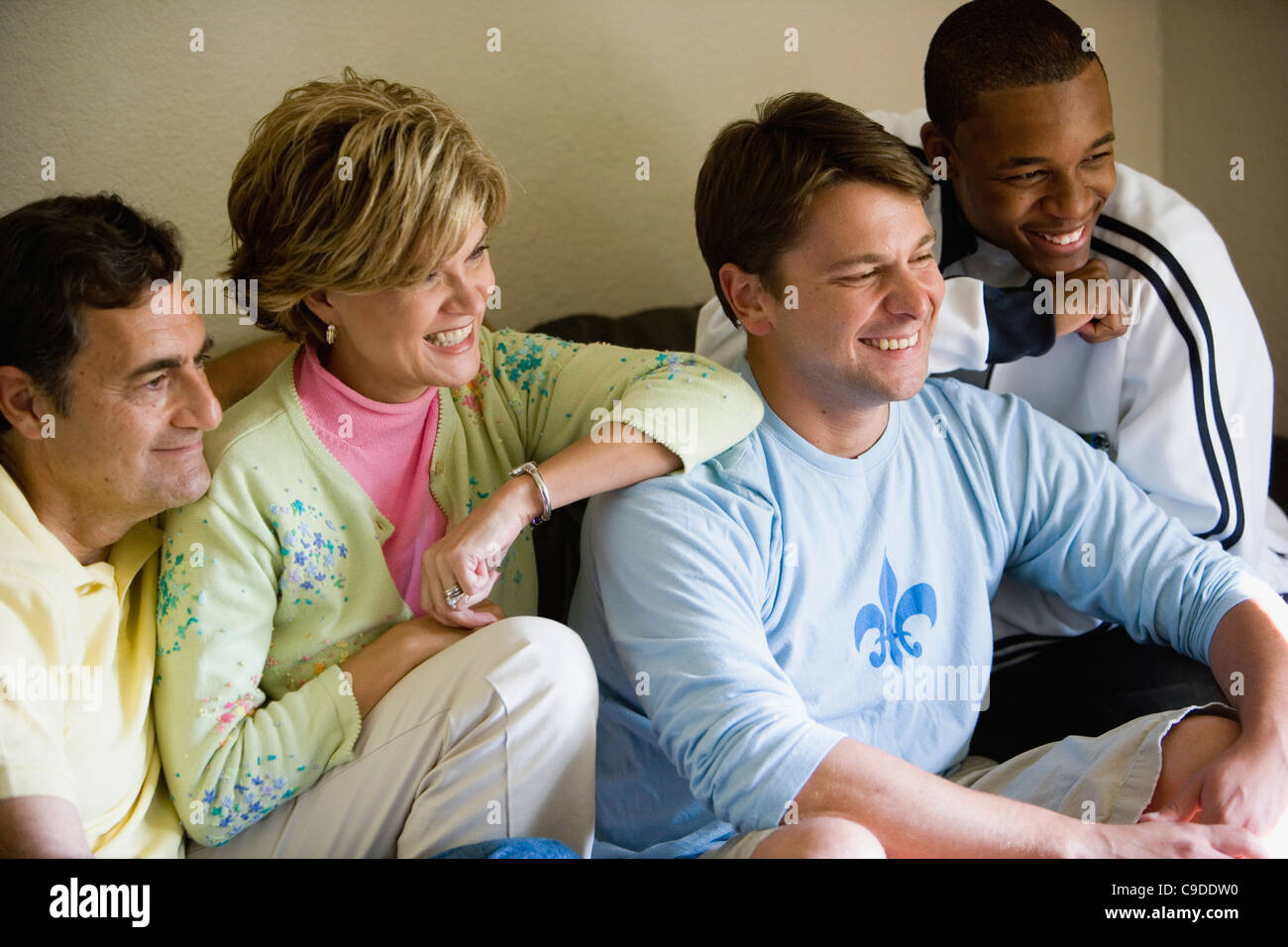 Four people sitting and watching Stock Photo - Alamy