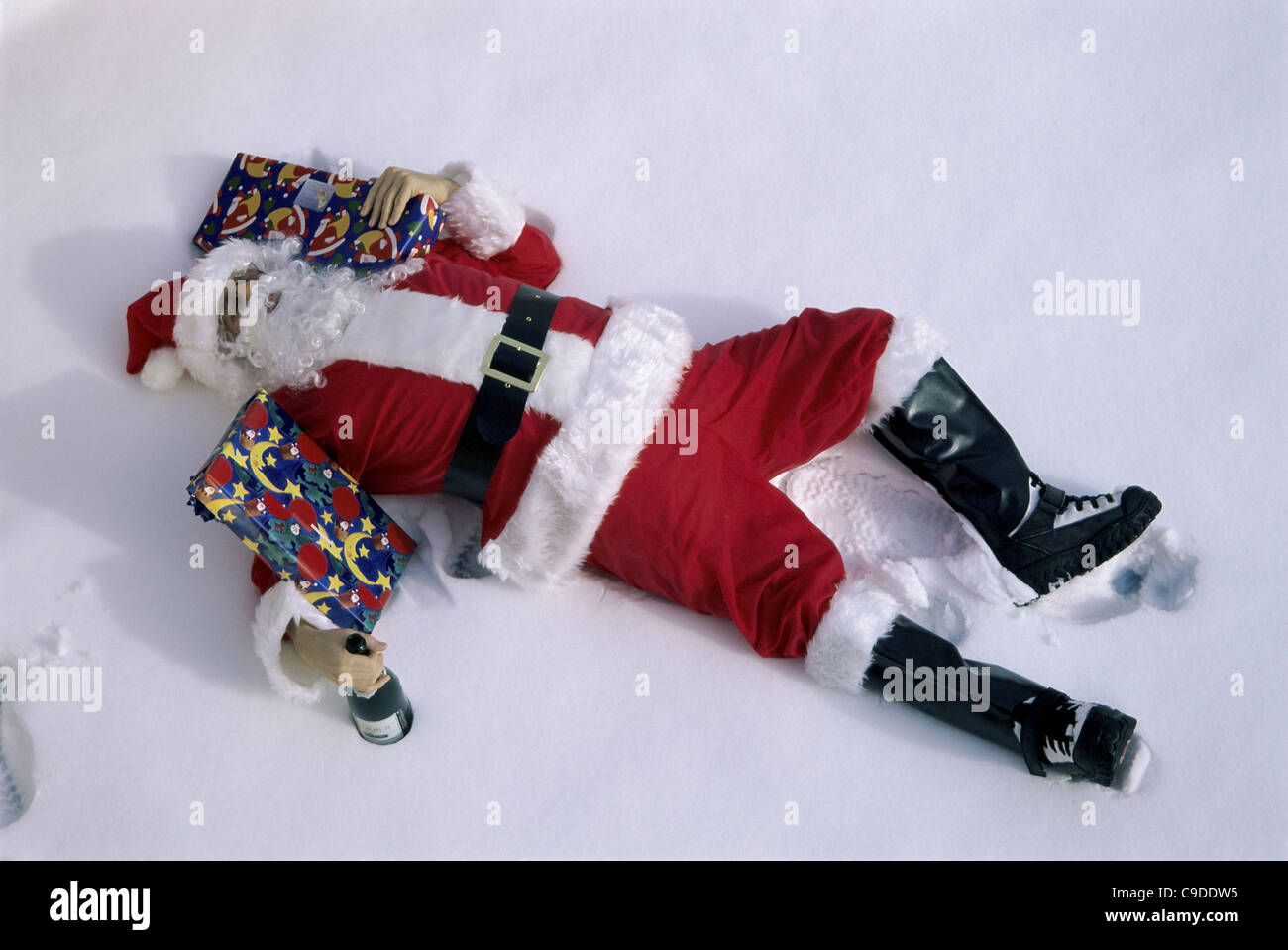 Santa Claus lying down in snow with gifts Stock Photo - Alamy