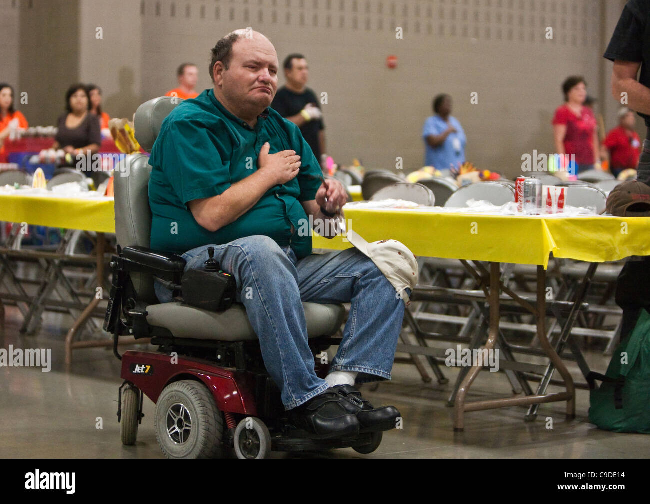 Attendees hold hand to heart during the pledge of allegiance at free ...