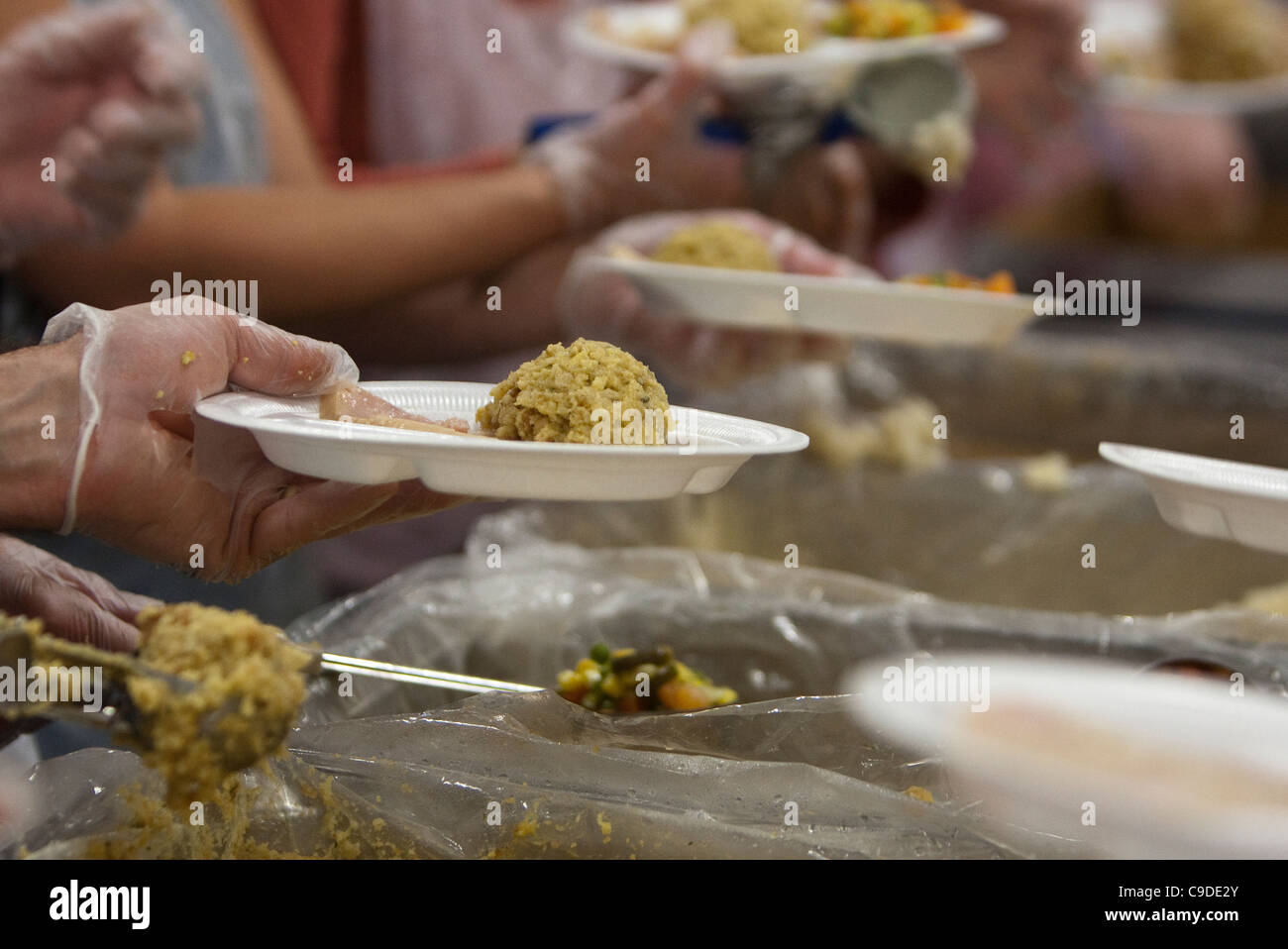 Volunteers hand serve and handout food to attendees of free ...