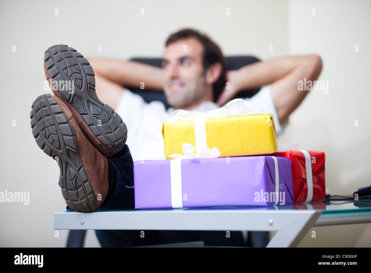 Man with feet up on table and gifts Stock Photo - Alamy