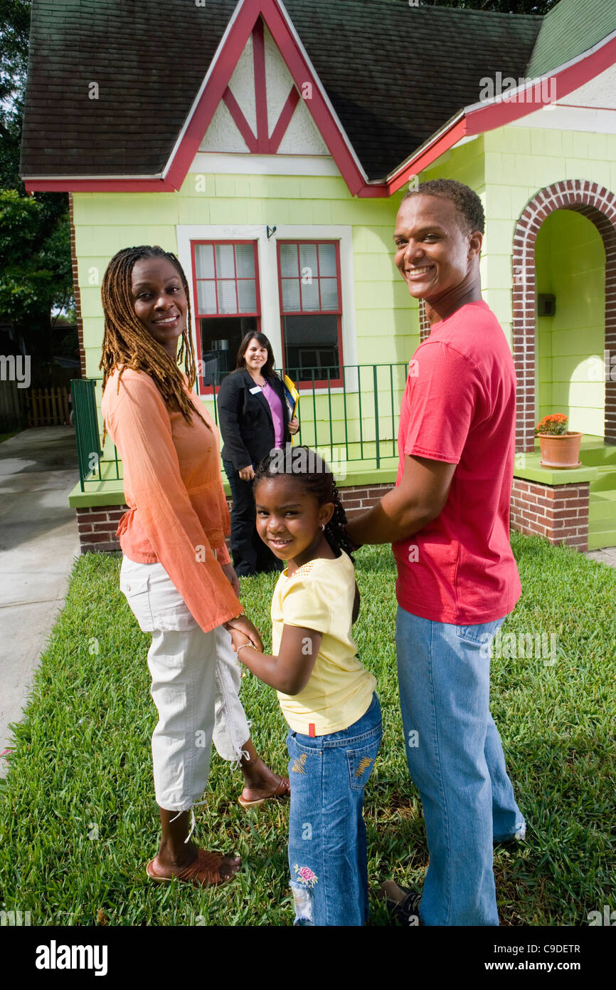 Portrait of family standing outside house with real estate broker Stock ...