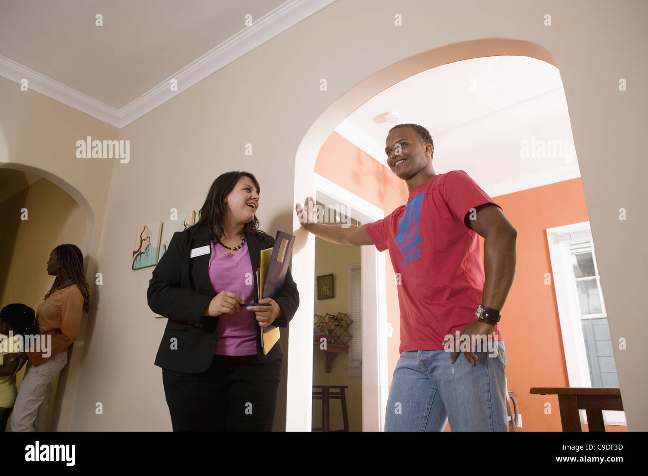 Real estate broker showing house to buyers Stock Photo - Alamy