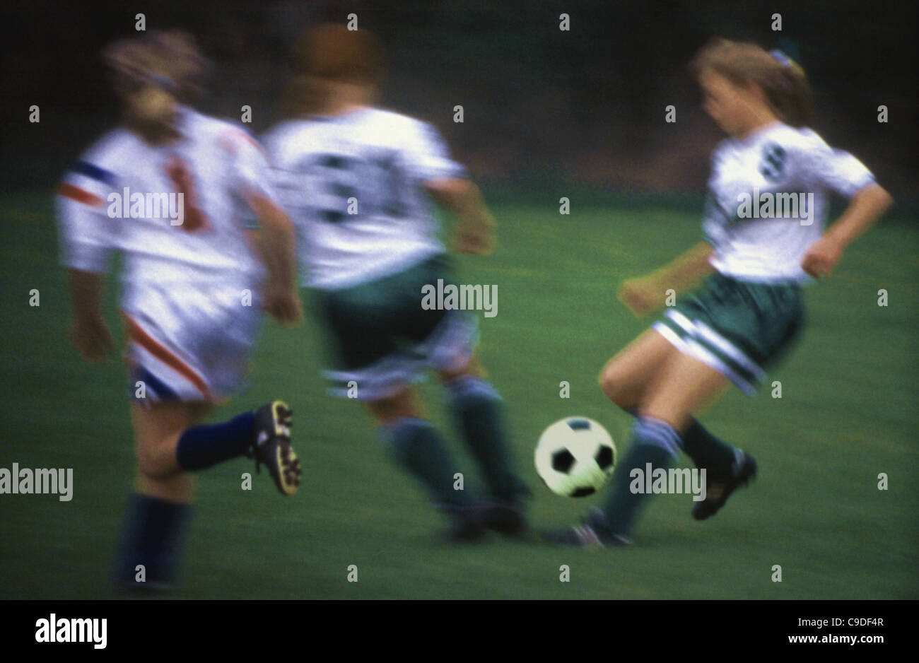 Girls playing soccer on a field Stock Photo - Alamy