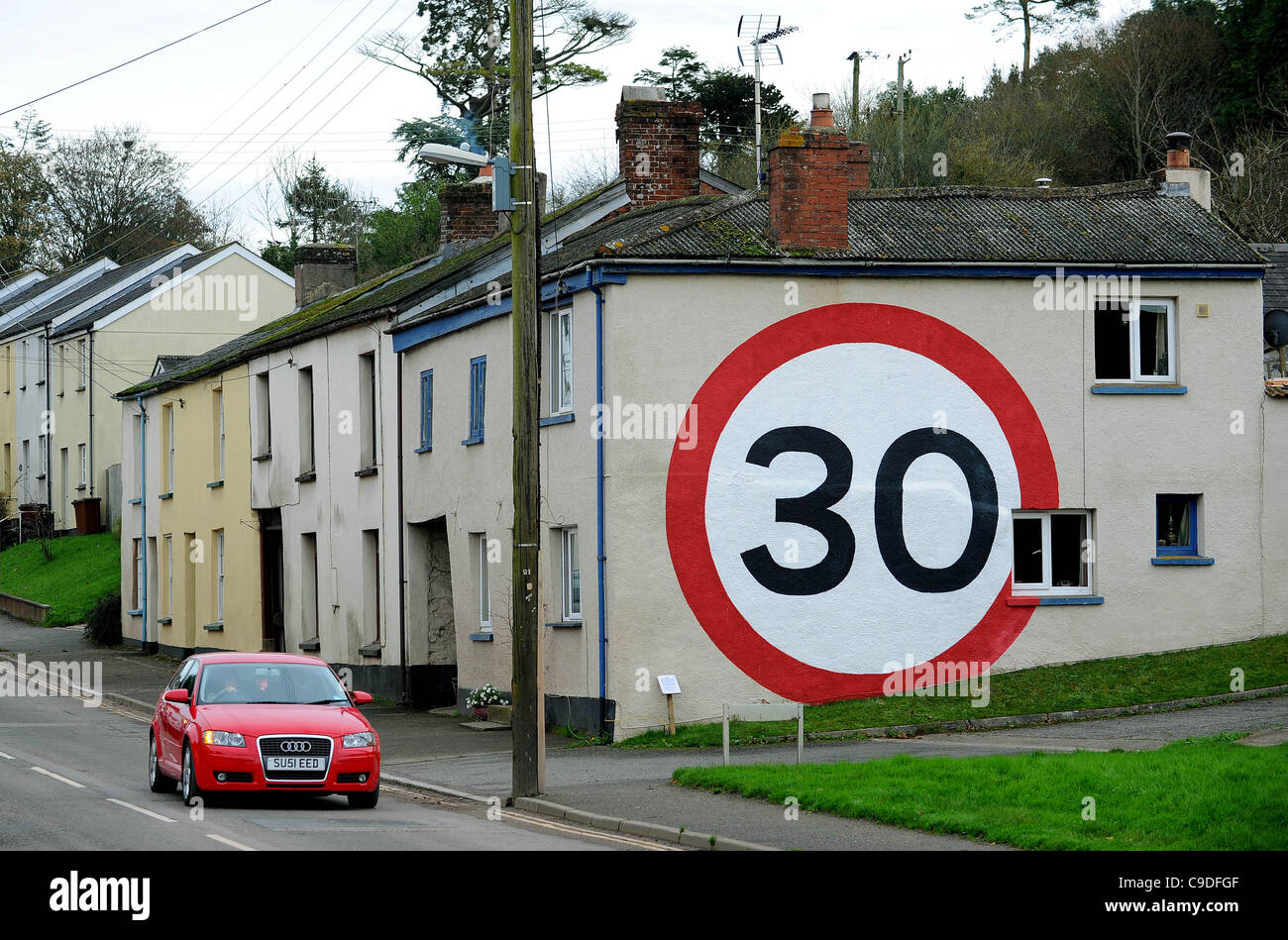 23.11.11. A giant painted 30mph road sign on the side of a house to ...