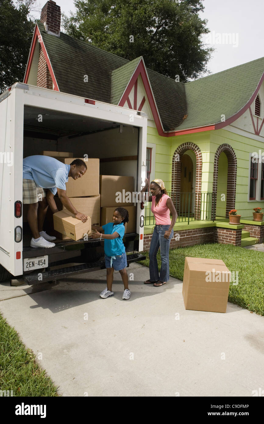 Family unloading boxes from moving truck Stock Photo - Alamy