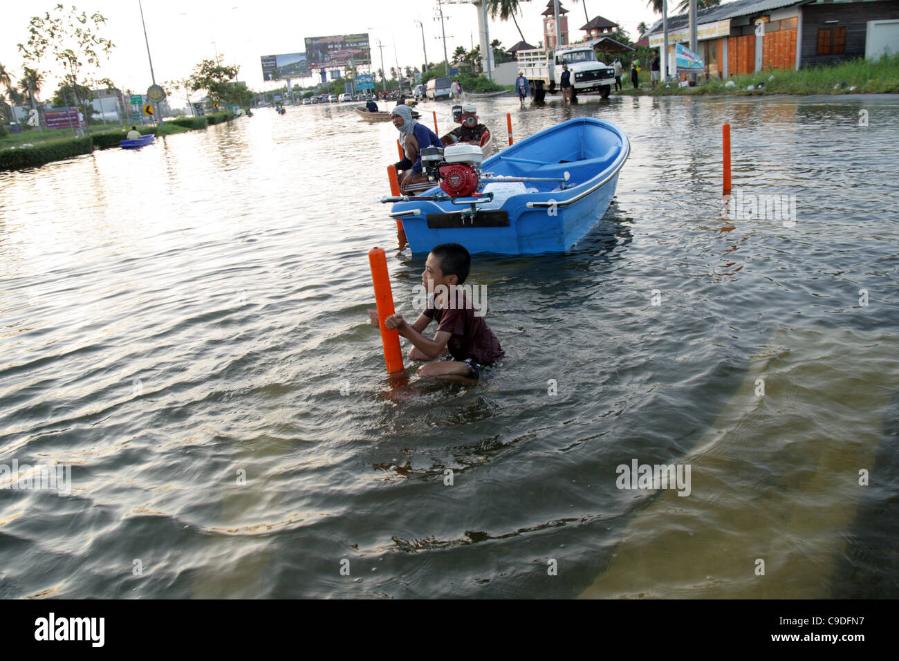Boy playing in floodwaters on street at Pakkred , Nonthaburi province ...