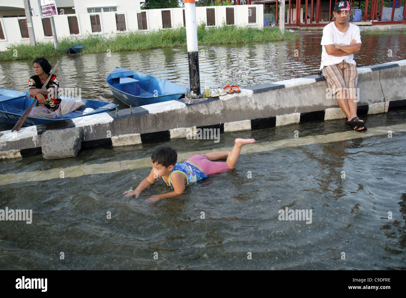 Boy playing in floodwaters at Pakkred , Nonthaburi province , Thailand ...