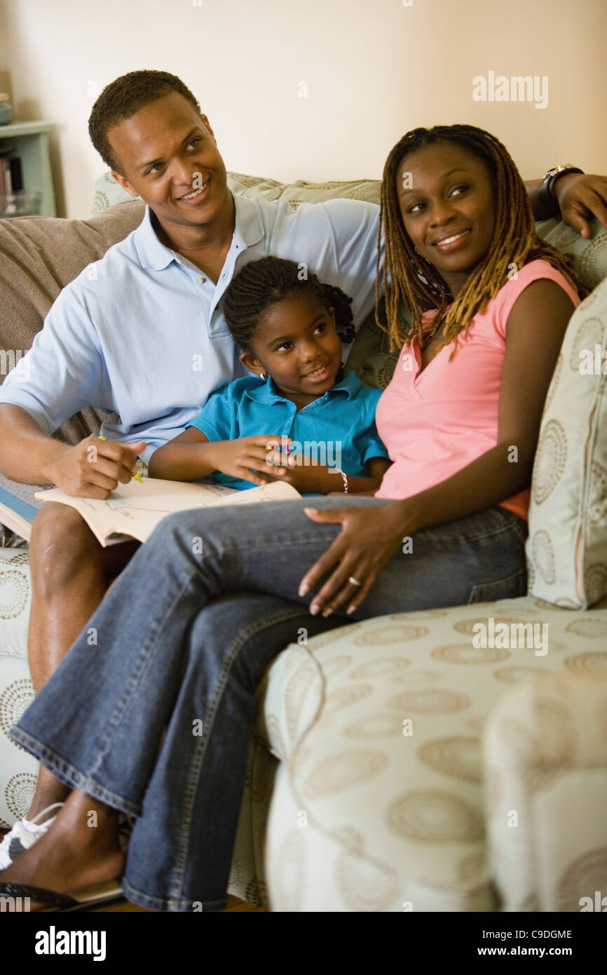 Parents reading and coloring with daughter Stock Photo - Alamy