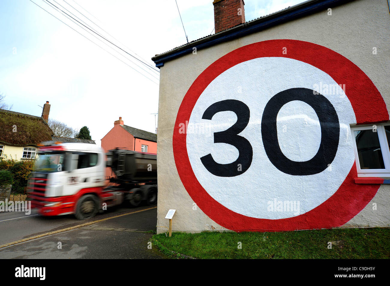 23.11.11. A giant painted 30mph road sign on the side of a house to ...