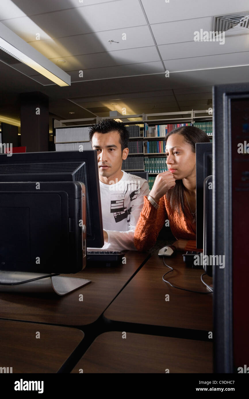 Two university students using computers in the library Stock Photo - Alamy