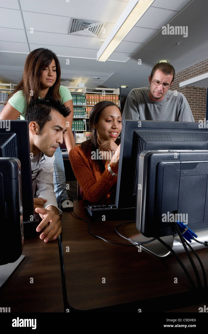 Young students using computers in the library Stock Photo - Alamy