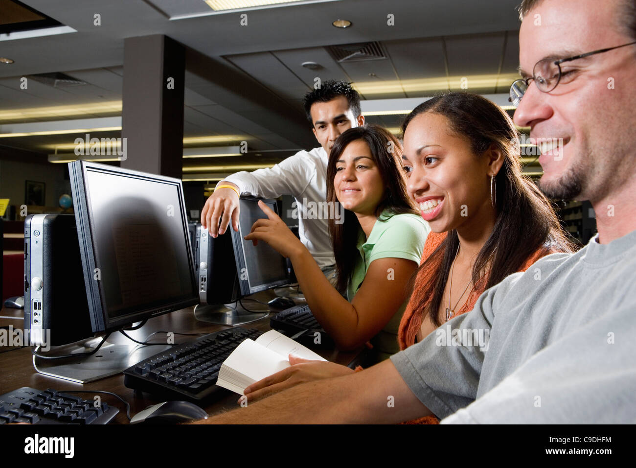 Young students using computers in the library Stock Photo - Alamy