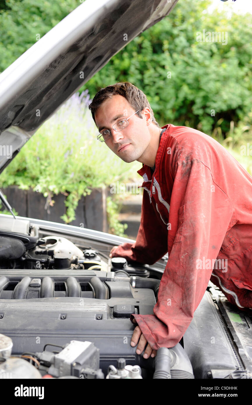 young man looking at the car engine. Outdoors Stock Photo - Alamy