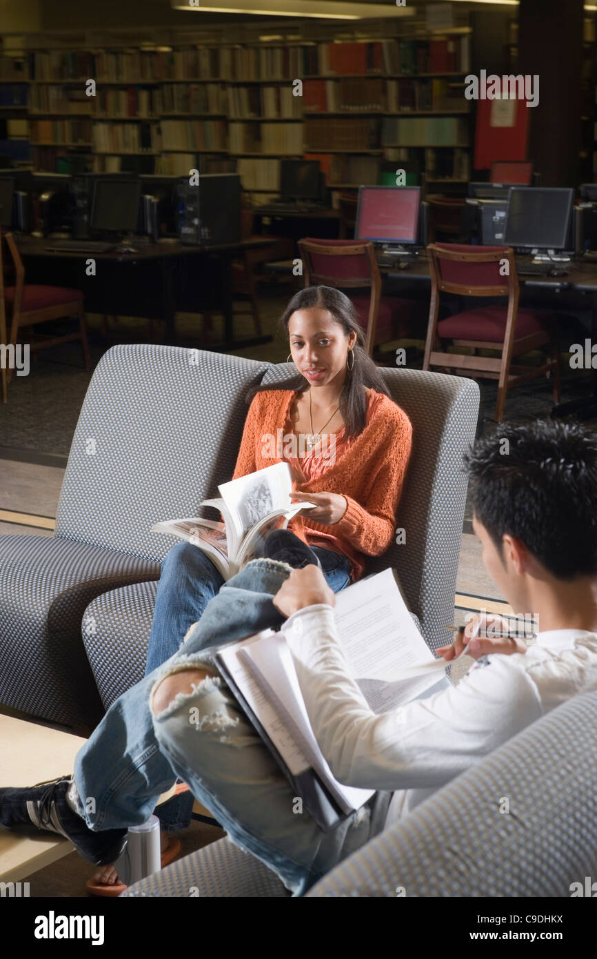 Students in library sitting on chairs studying Stock Photo - Alamy
