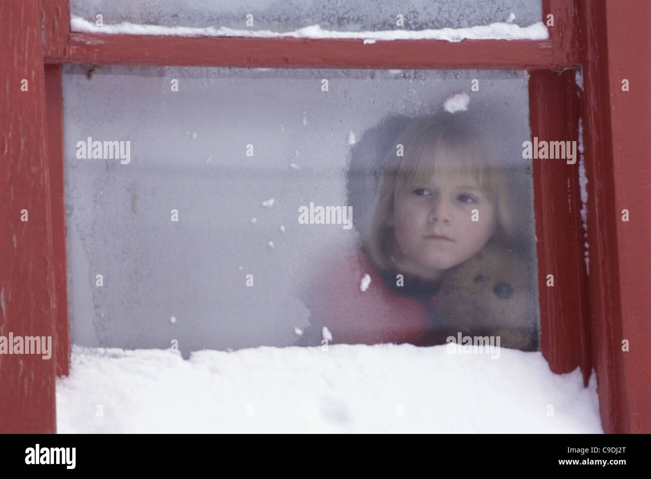 Girl looking through a window Stock Photo - Alamy