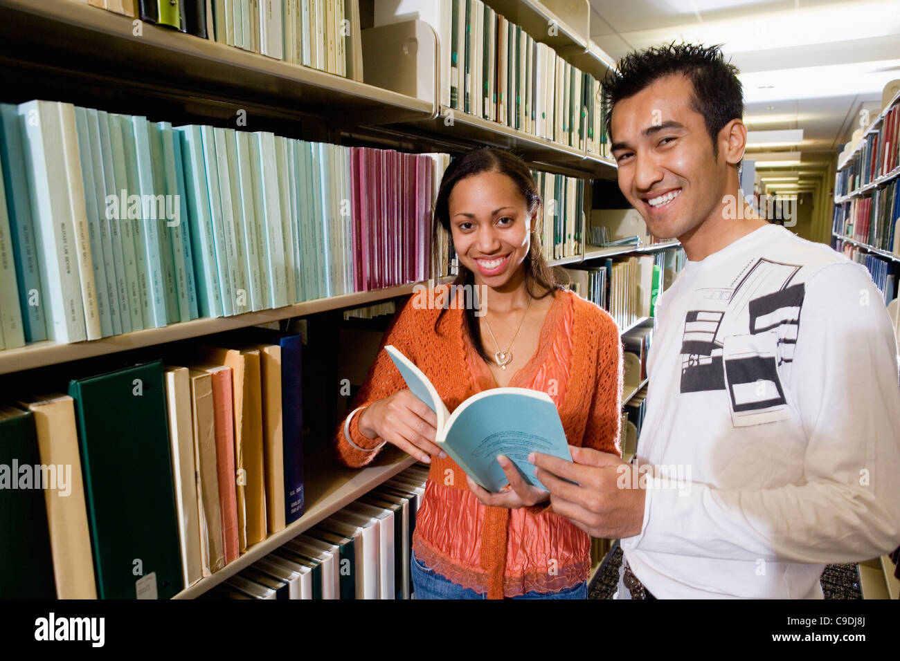 Students in the library looking through book stacks Stock Photo - Alamy