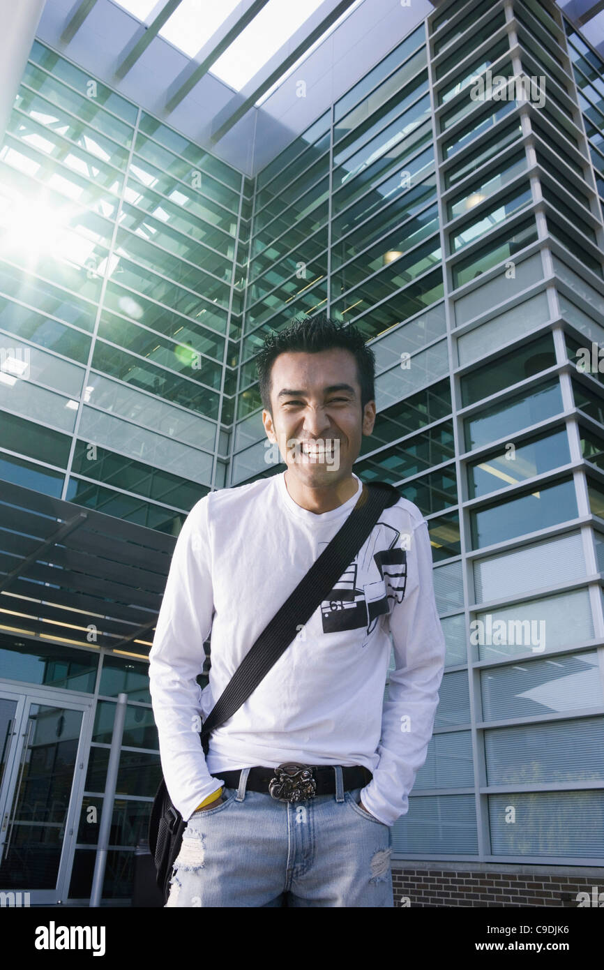University student standing outside campus building Stock Photo - Alamy