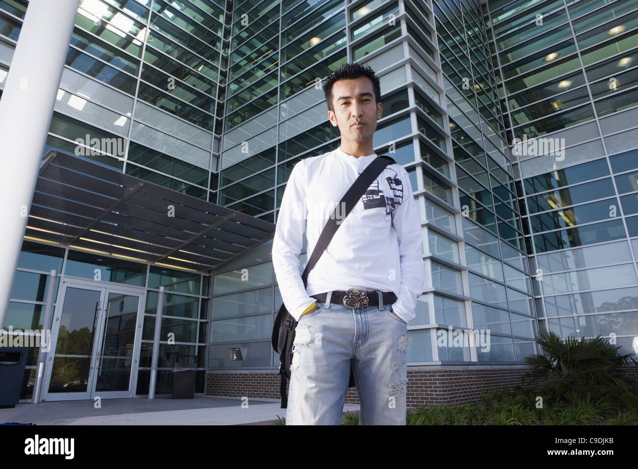 University student standing outside campus building Stock Photo - Alamy