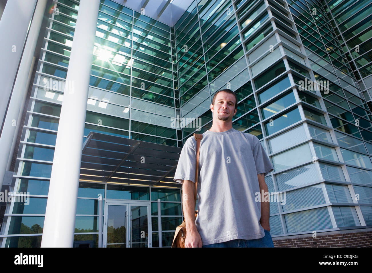 University student standing outside campus building Stock Photo - Alamy