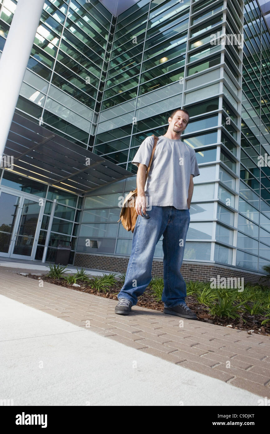 University student standing outside campus building Stock Photo - Alamy
