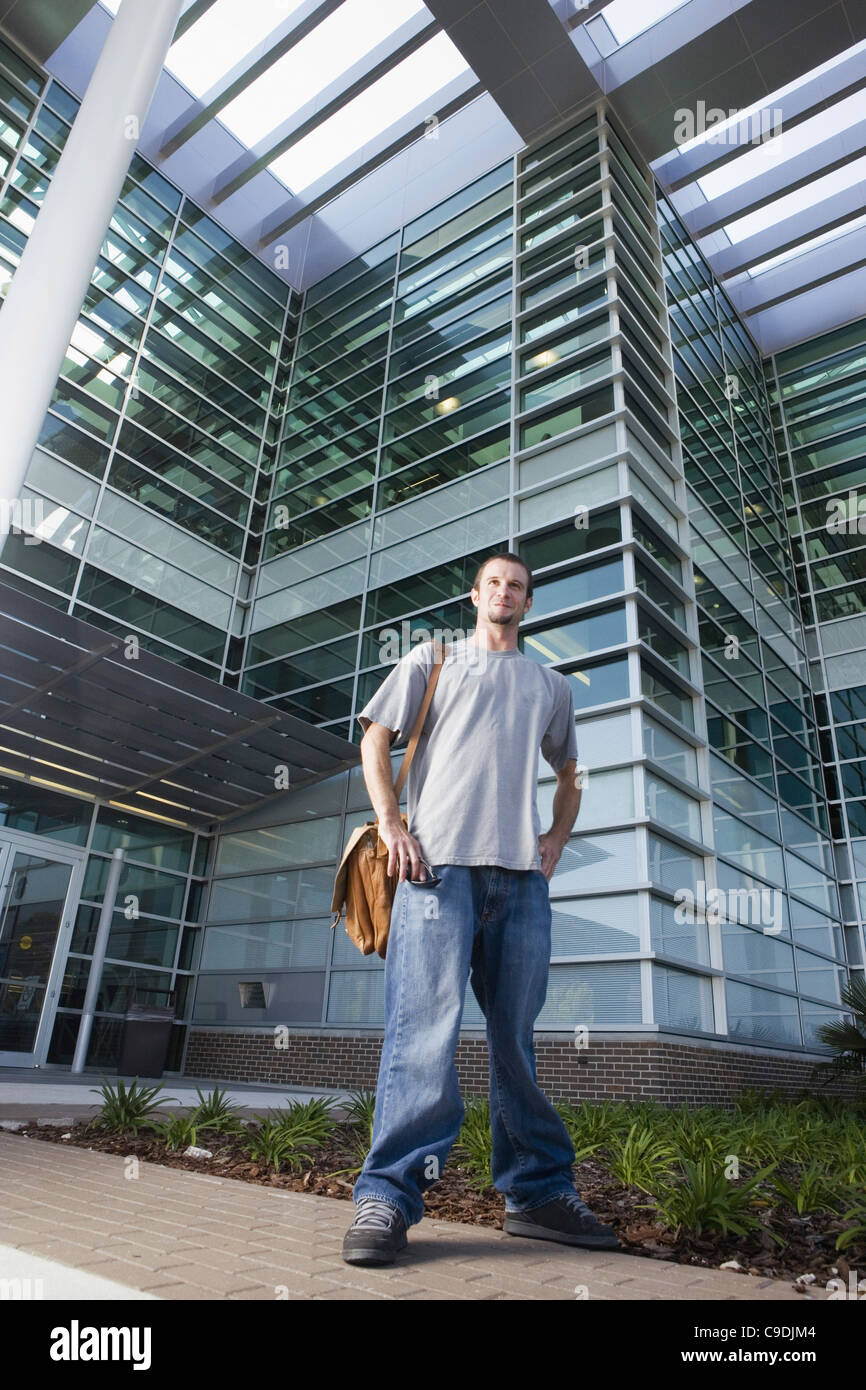 University student standing outside campus building Stock Photo - Alamy