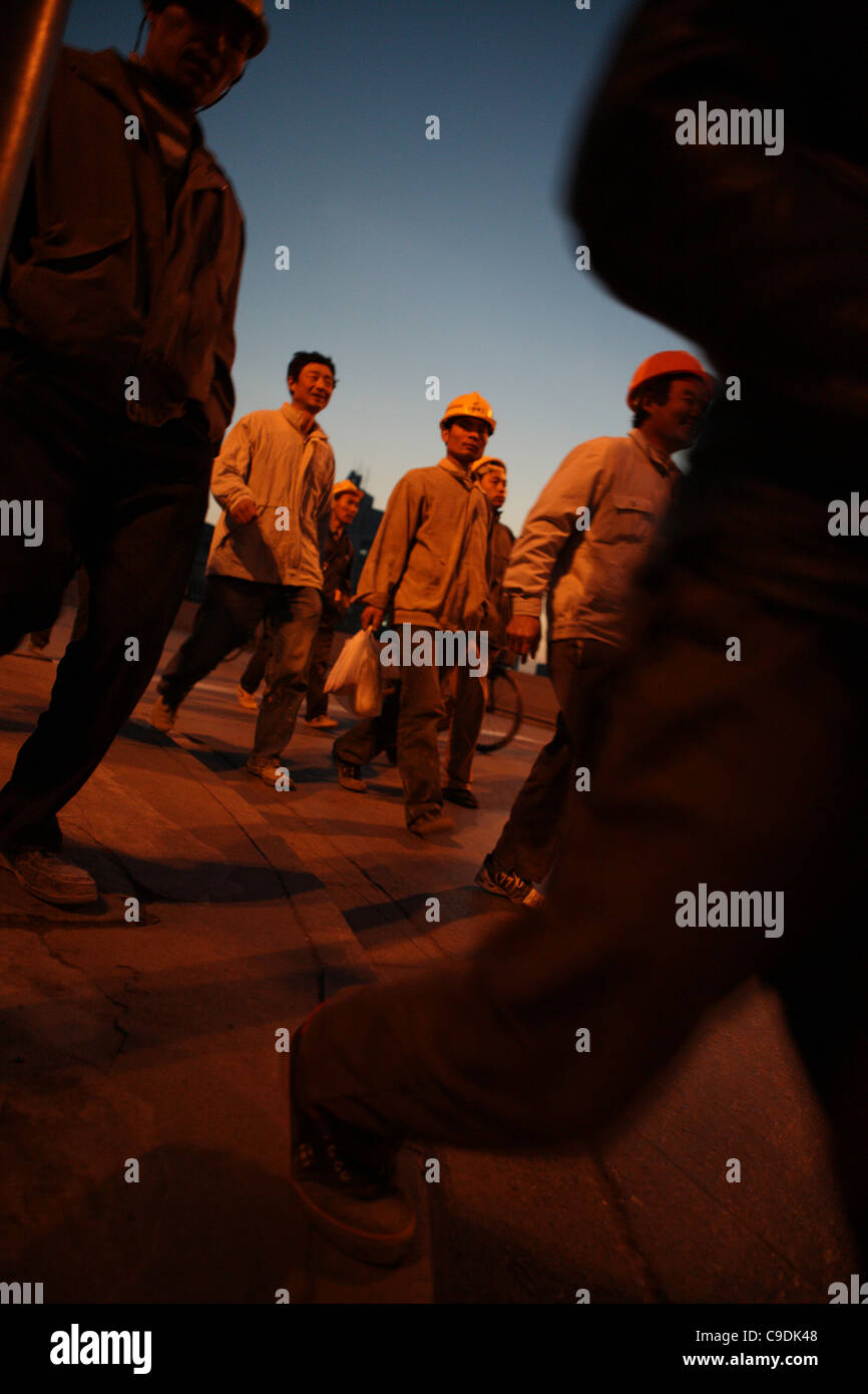 construction workers leaving a building site late at night, central ...