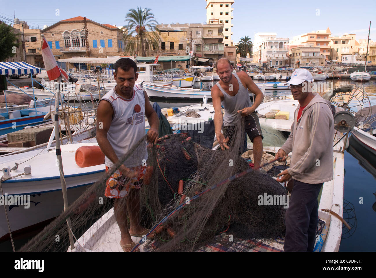 Fishermen tending their nets in the port of Tyre, southern Lebanon ...