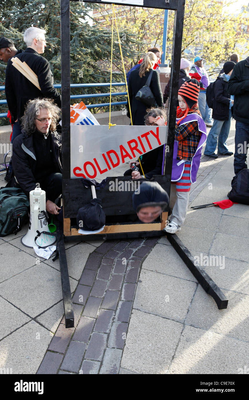 Birmingham, UK. 30th Nov, 2011. A girl operates a pretend guillotine to ...