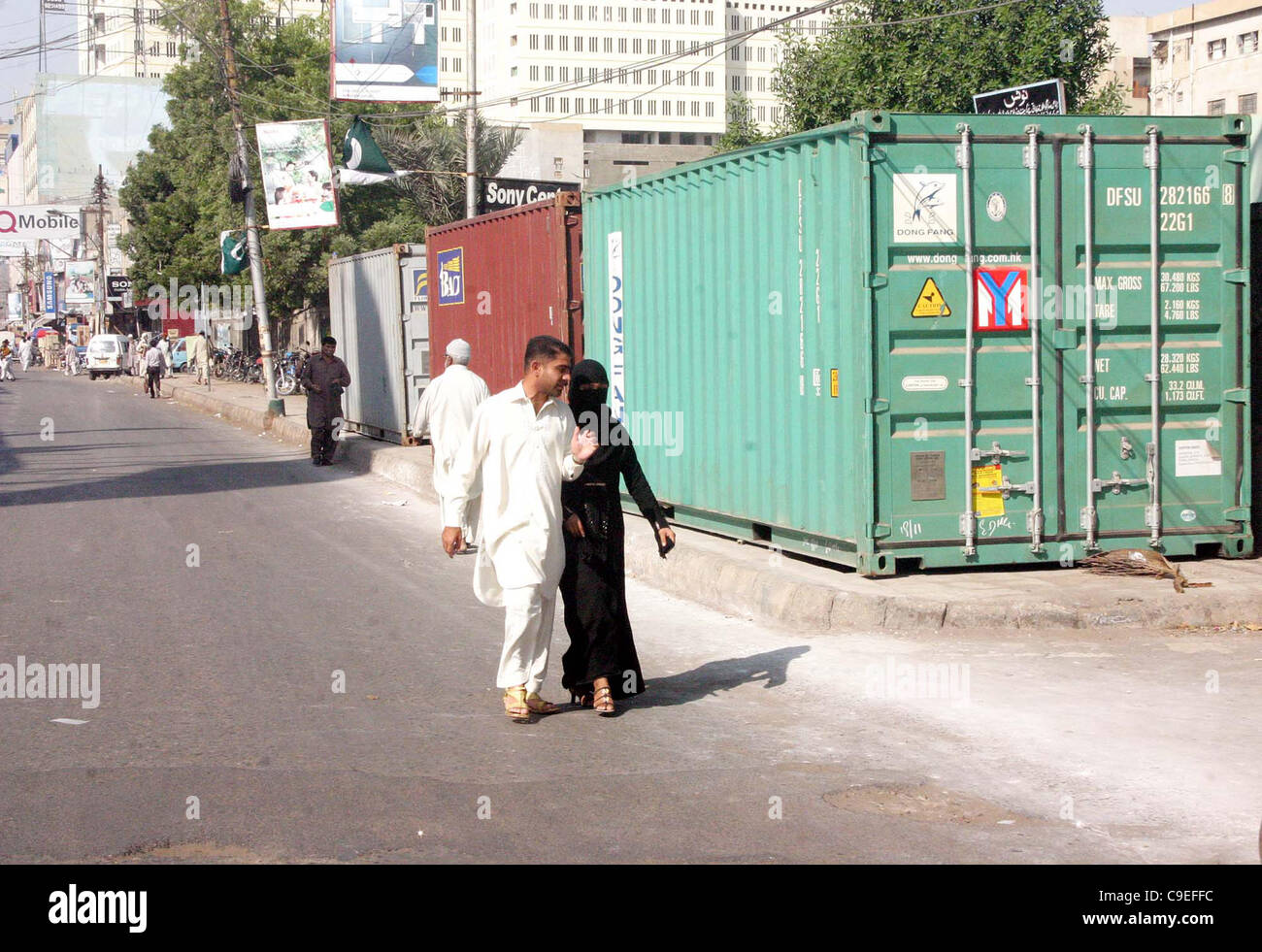Due to wrongly placed containers karachi pedestrians pass through road ...