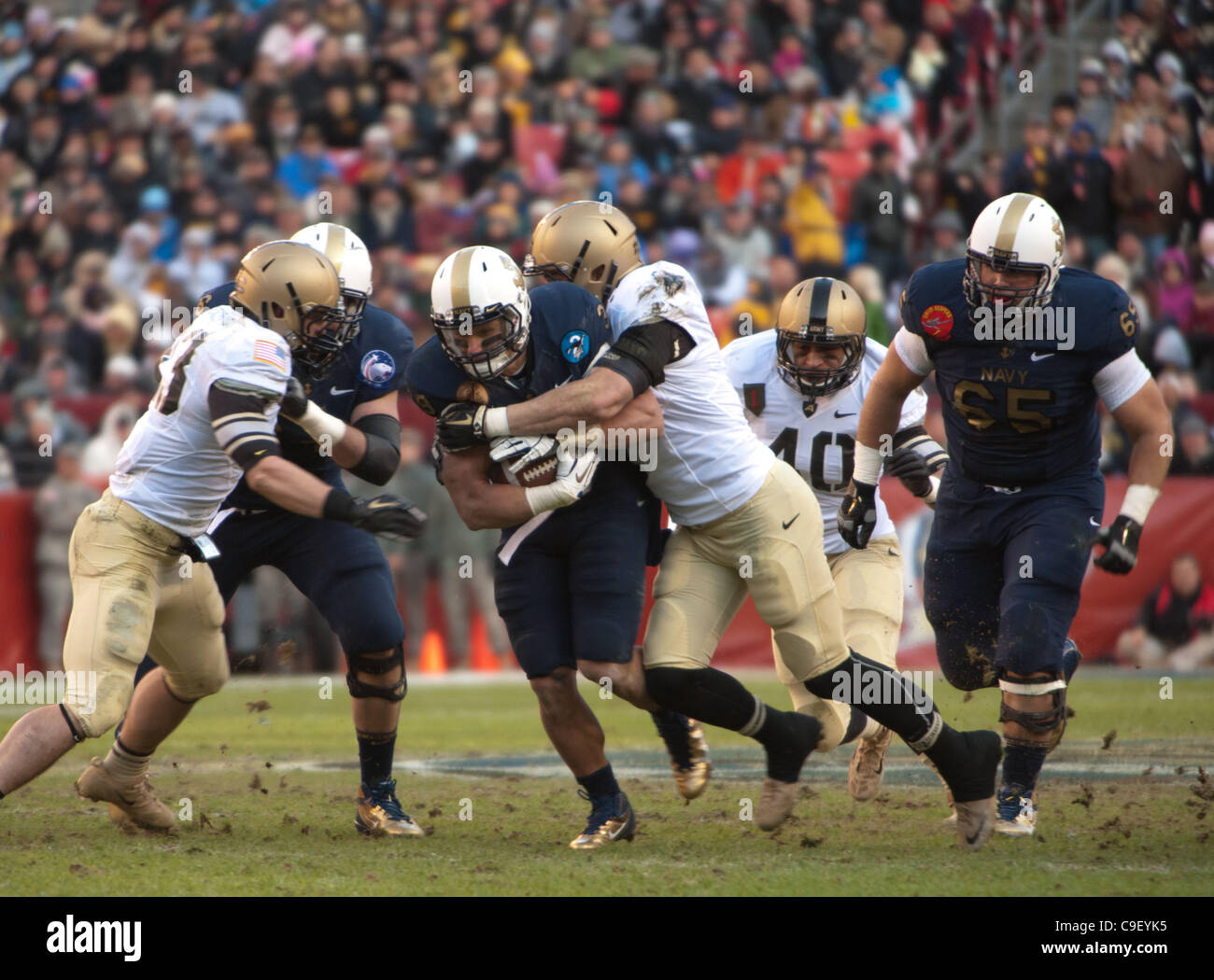 Navy's Alexander Teich is wrapped up by Army defenders in the first ...