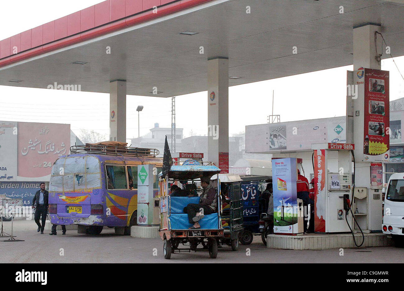A bus being filled with gas at a compressed natural gas (CNG) station ...