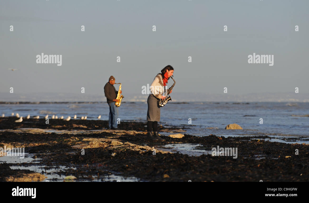 A pair of saxophone players make the most of the beautiful weather on ...