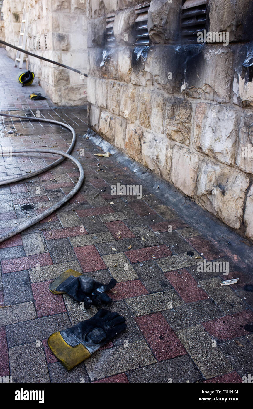 Used gloves, a hose and signs of soot as firefighters extinguish a ...