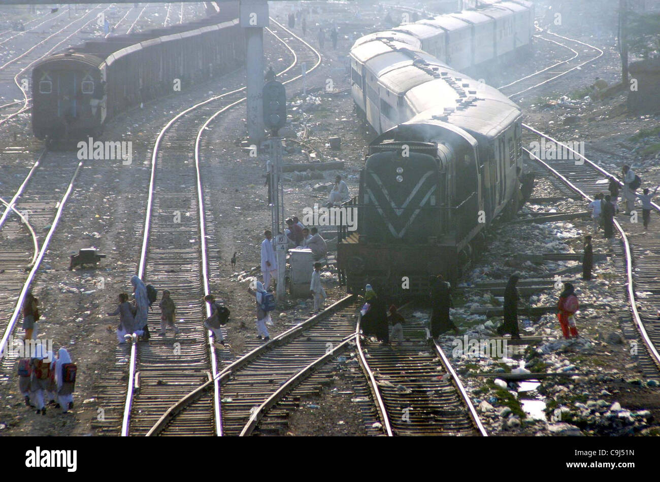 eiled women with children dangerously cross railway track while a ...