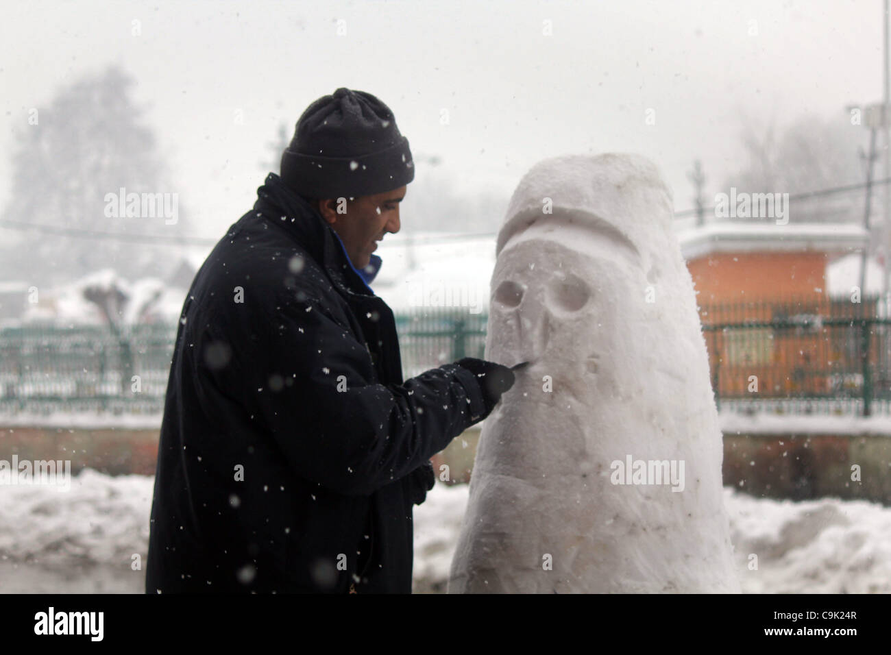 A kashmiri muslim making Snow man on a road during snow fall in ...