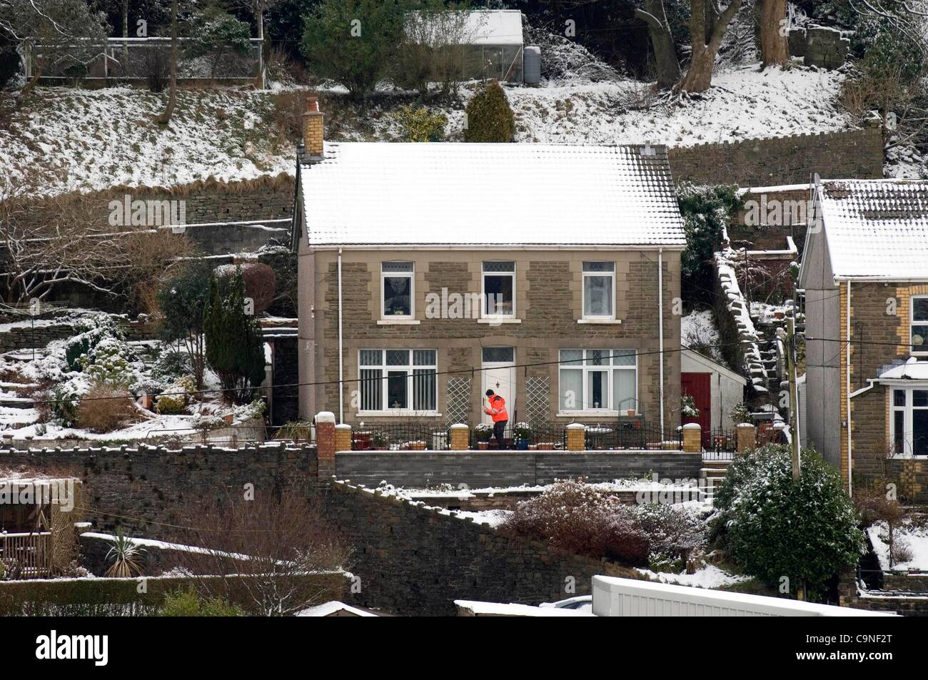 A postman delivering mail to the snow covered homes in Abergwynfi in ...