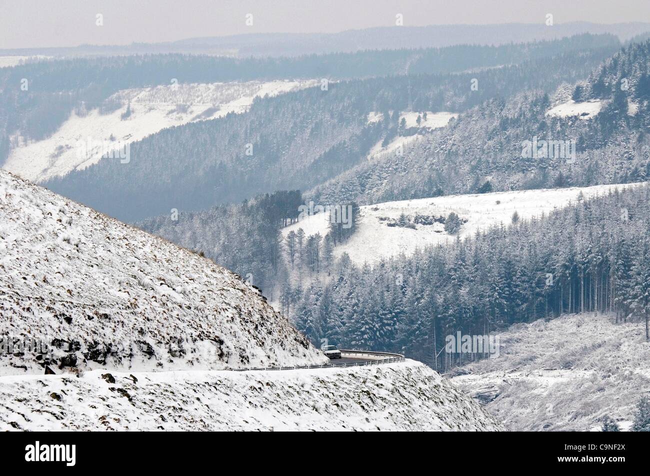 A lone car making it's way slowly up the snow covered remote mountain ...